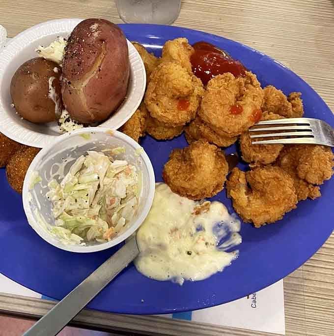 Golden fried shrimp with a baked potato and slaw proves that simple done right beats fancy every time.