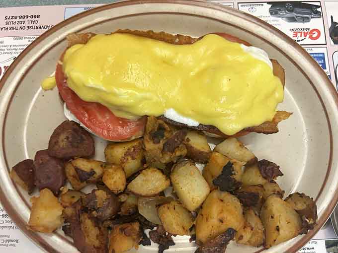 Eggs Benedict draped in hollandaise with perfectly crispy home fries proves breakfast is always the right choice here.