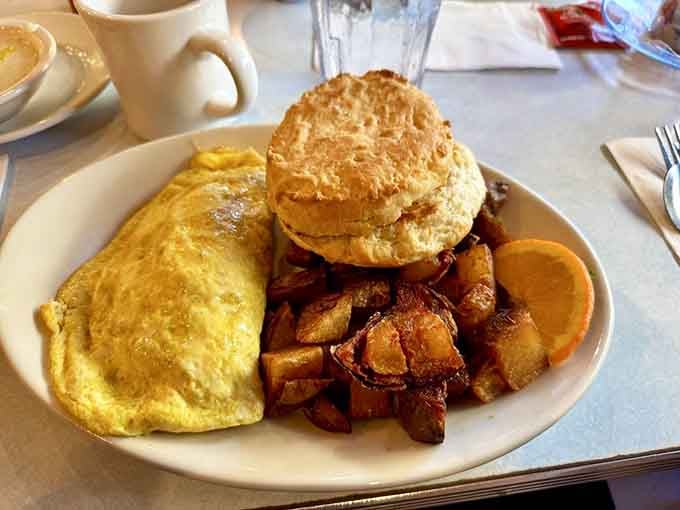 That fluffy omelet paired with crispy home fries and a towering biscuit is basically the breakfast equivalent of winning the lottery.
