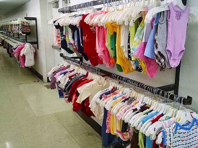 Rainbow rows of tiny onesies remind you that babies outgrow everything faster than you can say "consignment shop."