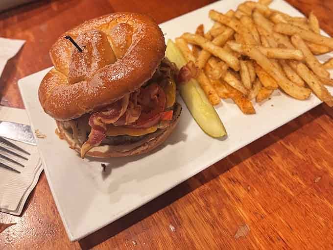 Behold the pretzel bun burger in all its glory, stacked high with toppings and flanked by golden fries.