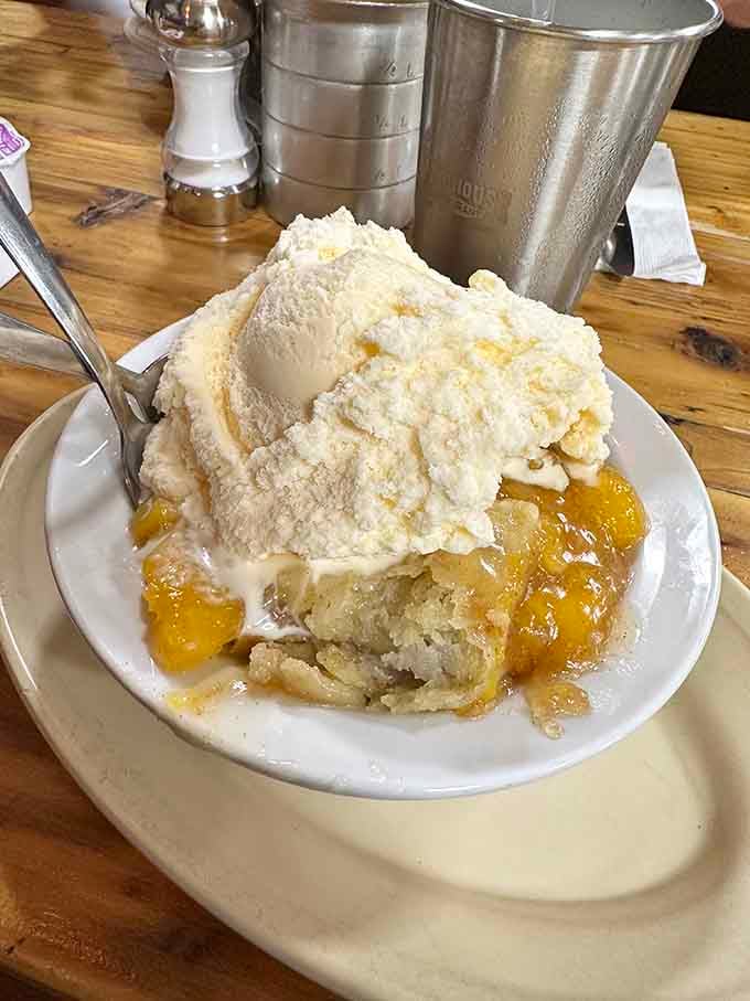 Behold the peach cobbler: a mountain of ice cream cascading over warm, fruity perfection below.