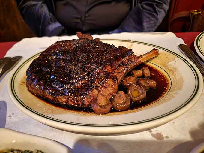 That bone-in ribeye sits in a pool of its own delicious juices, surrounded by mushrooms like edible treasure.