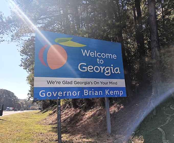 Morning sunlight kissing the sign creates a lens flare worthy of a Steven Spielberg film about coming home.