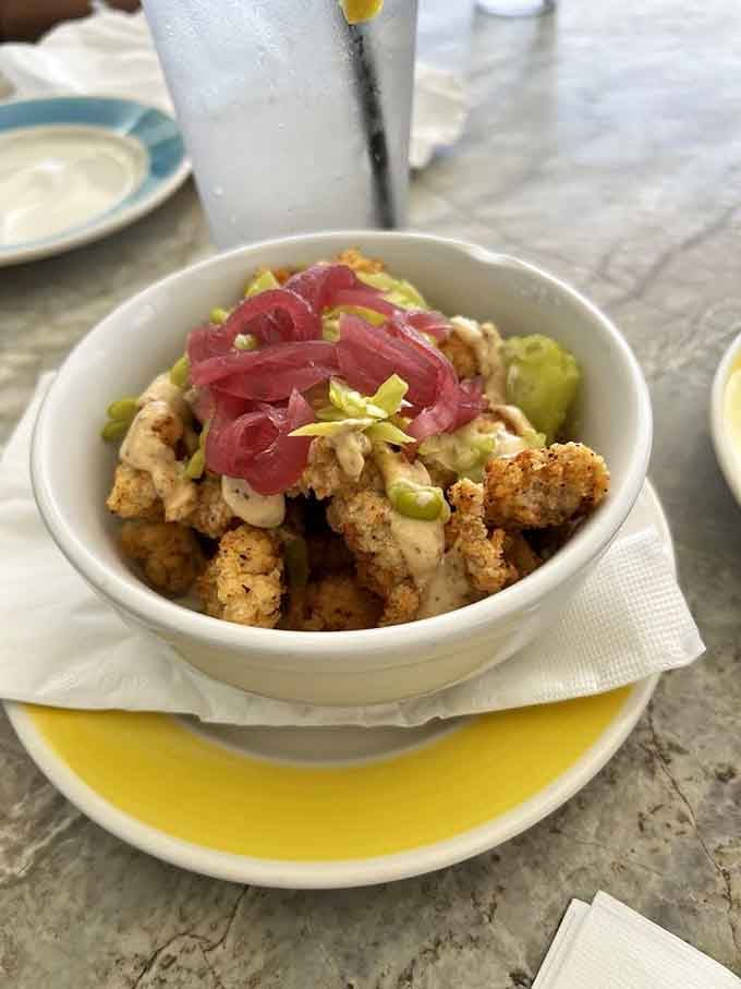Gator bites topped with pickled jalapeños and drizzled sauce, because Florida does appetizers with a little danger.