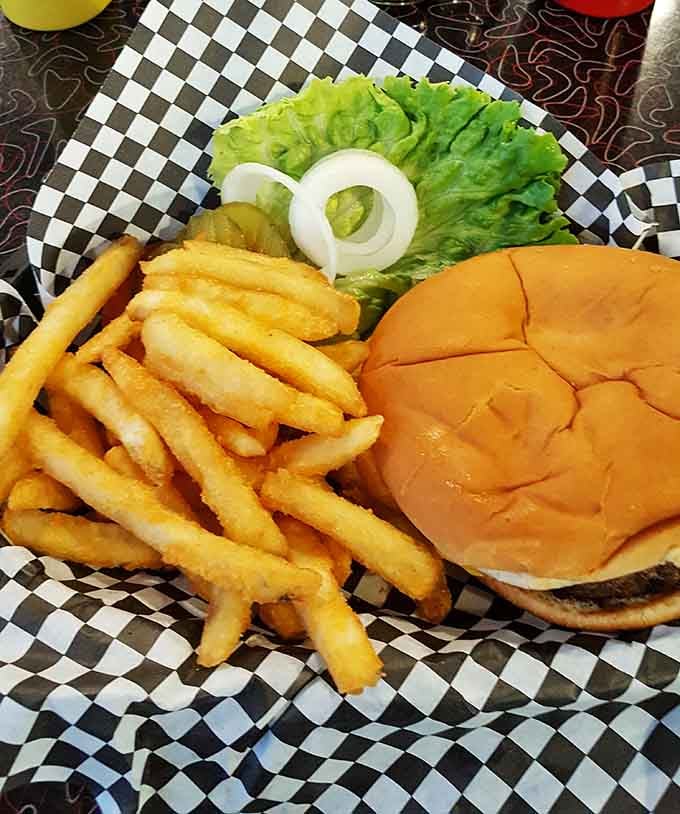Golden fries and a perfectly assembled cheeseburger served on checkered paper, like a picnic that actually lived up to expectations.