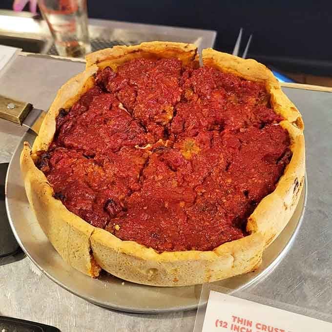 Behold the deep dish masterpiece with its towering crust standing proud like edible architecture at its finest.