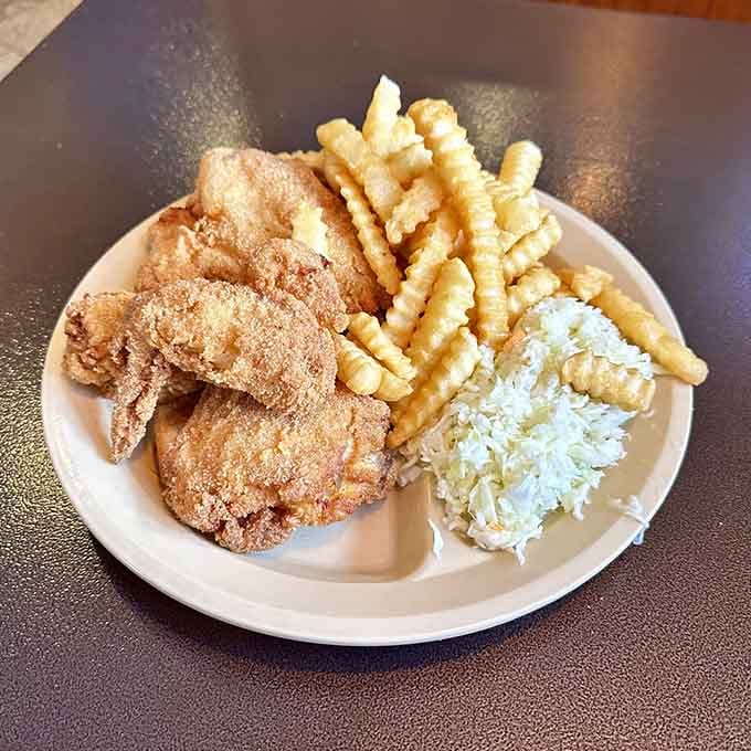 Golden fried chicken with crinkle fries and coleslaw, the holy trinity of comfort food done absolutely right.