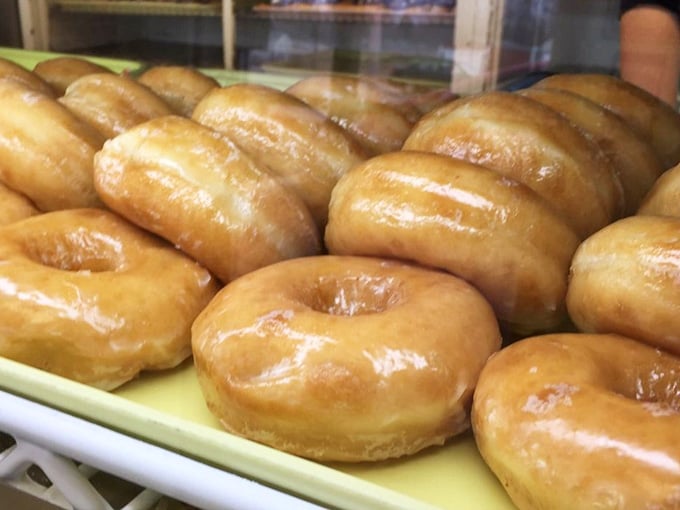 Golden rings of glazed perfection lined up like edible soldiers, ready to march straight into your heart and stomach simultaneously.