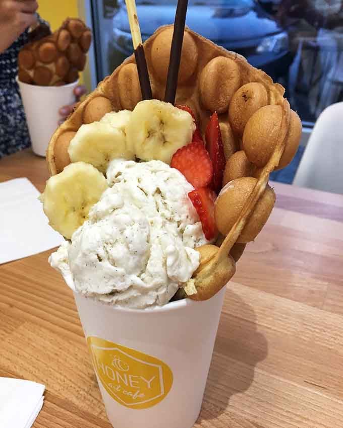 That bubble waffle cradles ice cream and fresh fruit like edible architecture, too pretty to demolish immediately.