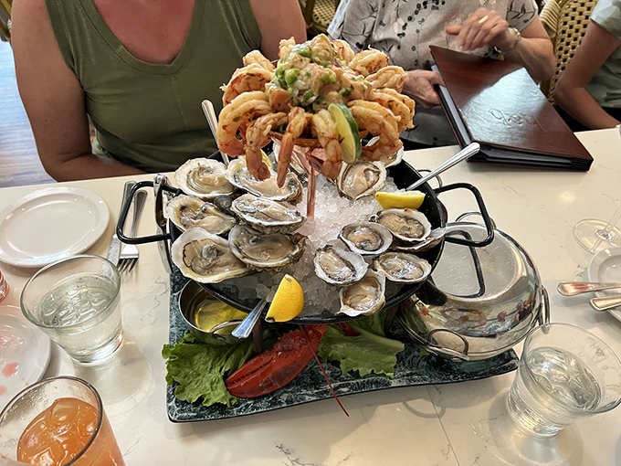 The seafood tower arrives like a skyscraper of shellfish, crowned with fried shrimp that could make a grown person weep.