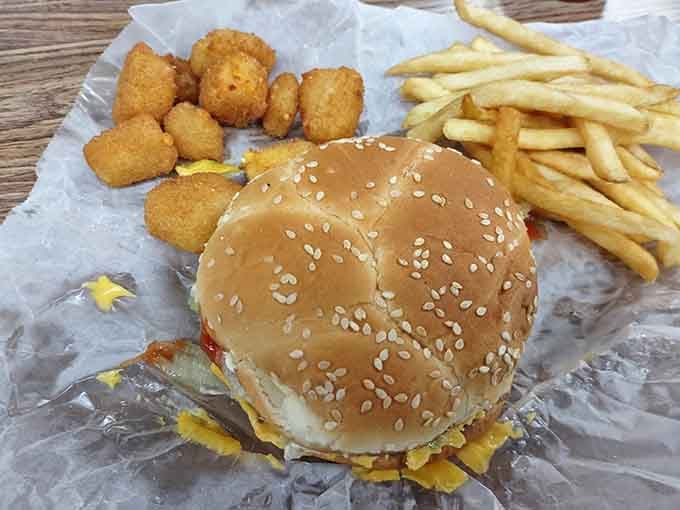 Sesame seed bun, golden fries, and those glorious tater tots proving simple perfection never goes out of style.