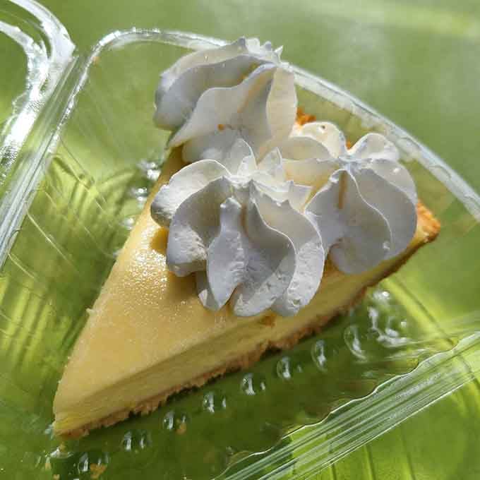 Classic key lime pie with its pale yellow filling and fluffy whipped cream, looking exactly like perfection should.