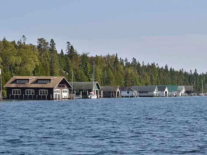 Historic boathouses stand sentinel over the harbor, protecting vessels that cost more than most people's retirement funds.