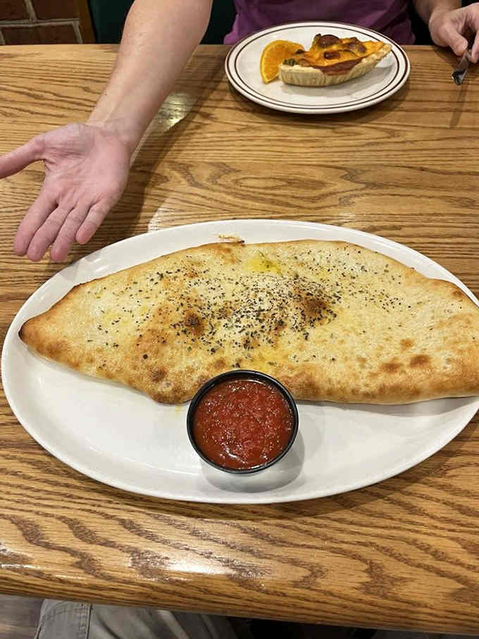 Behold the calzone that requires its own area code, golden and stuffed beyond all reasonable expectations.