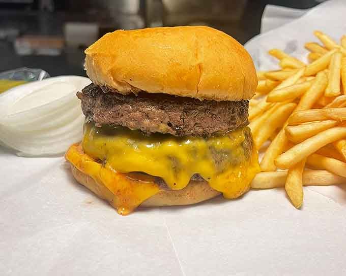 Behold the perfect burger: thin patty, melted cheese, soft bun, and enough grease to make cardiologists nervous but happy.