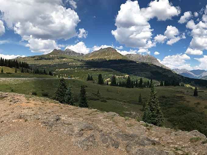 Alpine meadows stretch beneath dramatic peaks, proving Colorado's landscape has better range than most actors' careers.