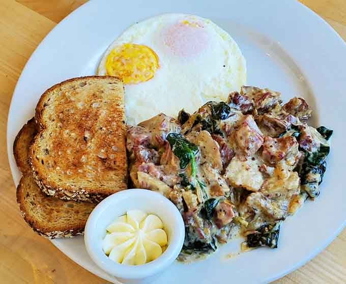 The CB Hash arrives looking like breakfast won the lottery, with eggs and toast supporting a mountain of deliciousness.