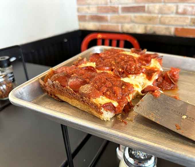 Behold the rectangular beauty: crispy edges, airy crust, and that signature sauce-on-top swagger that defies convention.