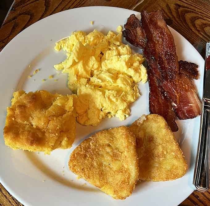 Golden perfection on a plate: scrambled eggs, crispy bacon, and those glorious fried green tomatoes stealing the show.