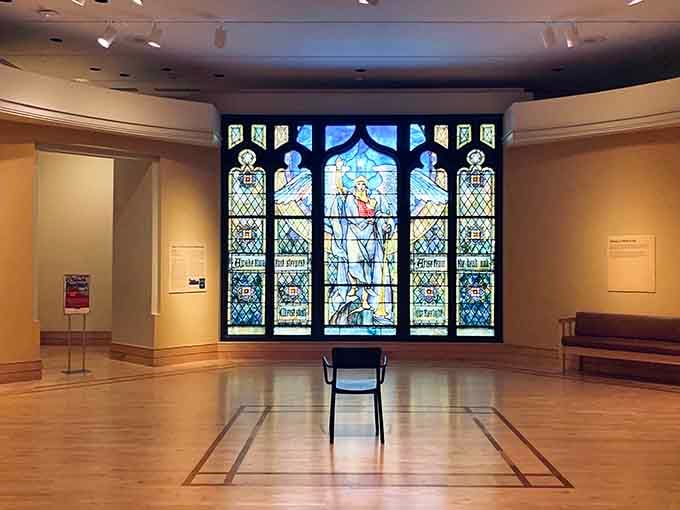 This stained glass masterpiece commands the gallery like a cathedral window transported through time and space.