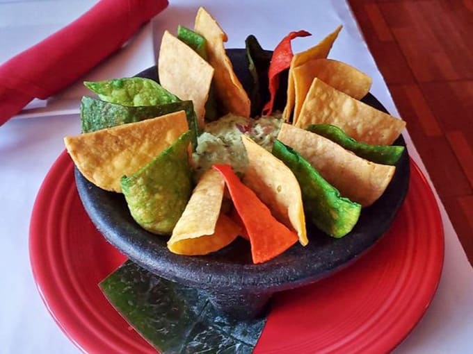 Multicolored tortilla chips arranged like edible art &ndash; because even guacamole deserves a proper stage entrance here.