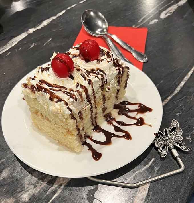 Four leches cake topped with cherries because apparently three types of milk just wasn't indulgent enough for anyone.