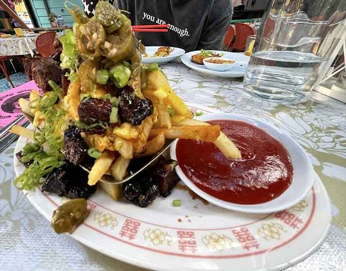 Behold the tower of temptation: crispy fries buried under BBQ pork that'll haunt your dreams in the best way.