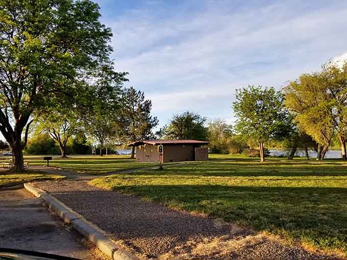 Golden light filters through mature trees, casting long shadows across grass that's perfect for barefoot evening strolls.