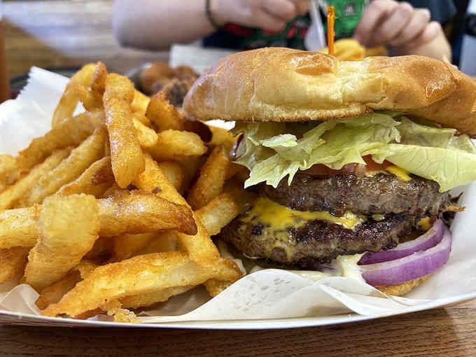 This double-stacked beauty arrives with perfectly seasoned fries, proving simple done right beats fancy every time.