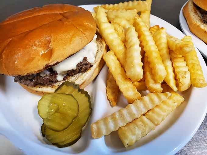 Behold the burger that launched a thousand napkins, served with crinkle fries and pickles that know their supporting role.