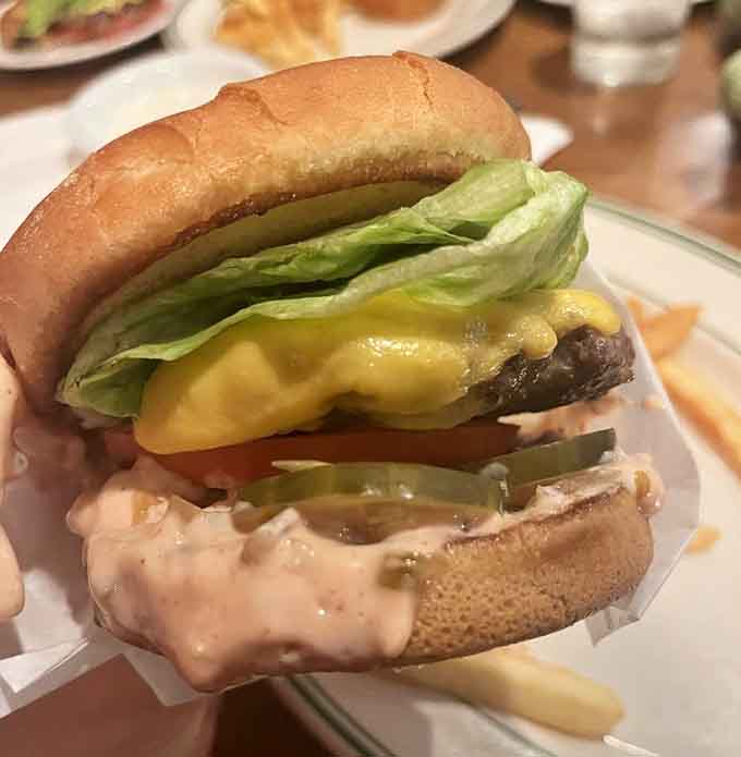 Behold the cheeseburger that launched a thousand road trips, complete with melted cheese cascading over a serious beef patty.