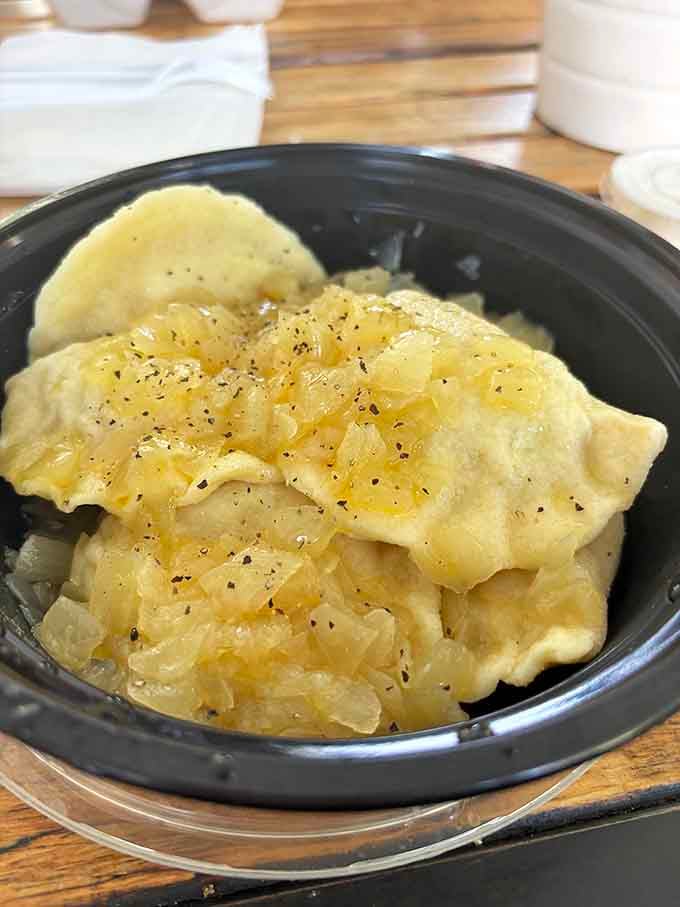 Golden pierogies topped with caramelized onions prove that simple ingredients can create absolute magic on a plate.