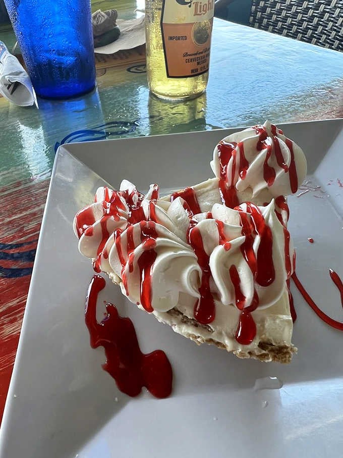 Mountains of whipped cream and strawberry drizzle crown this traditional slice like it's dessert royalty at court.