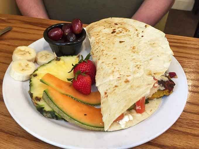 The falafel wrap arrives looking like it could solve world peace, one delicious Mediterranean bite at a time.