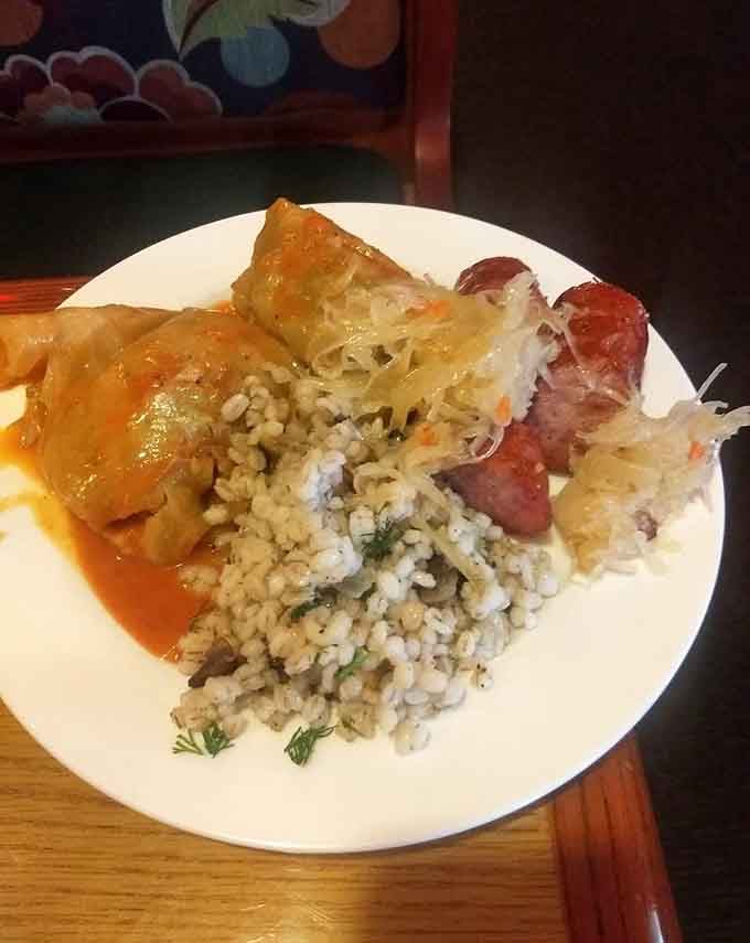 Golabki and kielbasa sharing plate space like old friends reuniting, with rice playing enthusiastic third wheel nearby.