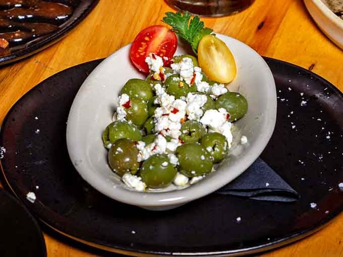 Olives dressed in feta like they're attending the fanciest Mediterranean garden party you've ever seen.