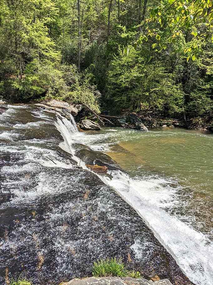 Water cascades over dark rocks in silvery sheets, creating the kind of natural beauty that makes your phone camera seem inadequate.