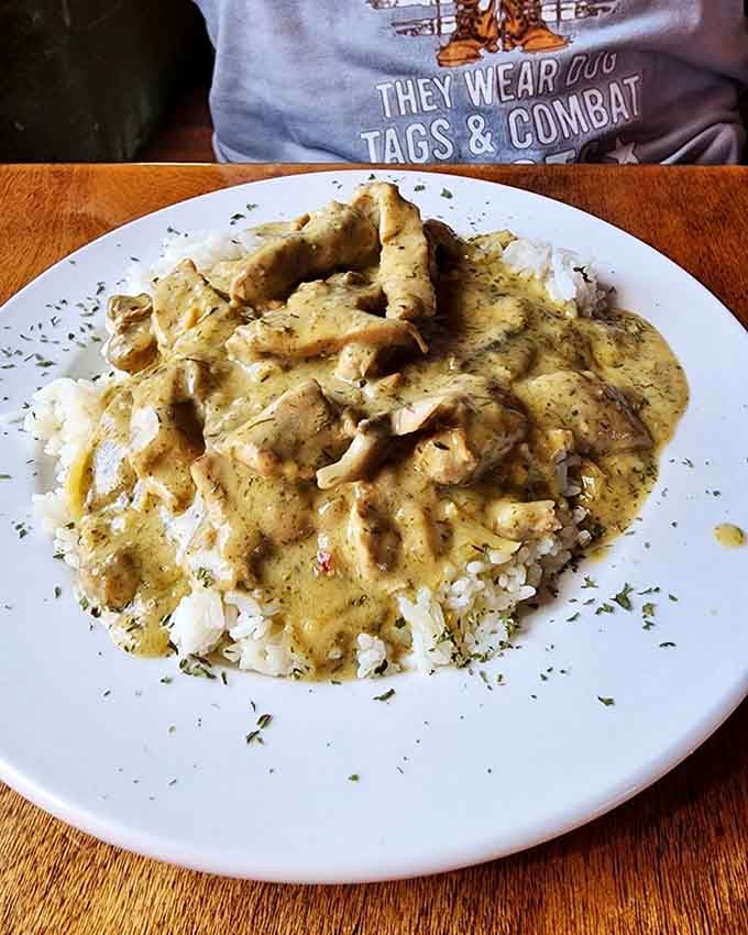 Tender pork strips swimming in herbed cream sauce over rice, proving Germans understood comfort food long before it was trendy.