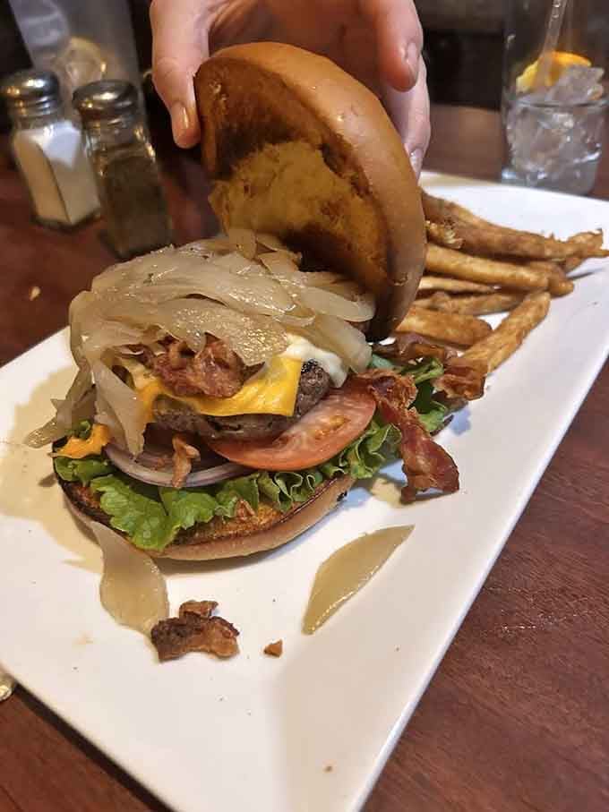 The Garbage Burger earns its name with pride, piled so high it requires architectural engineering to eat properly.