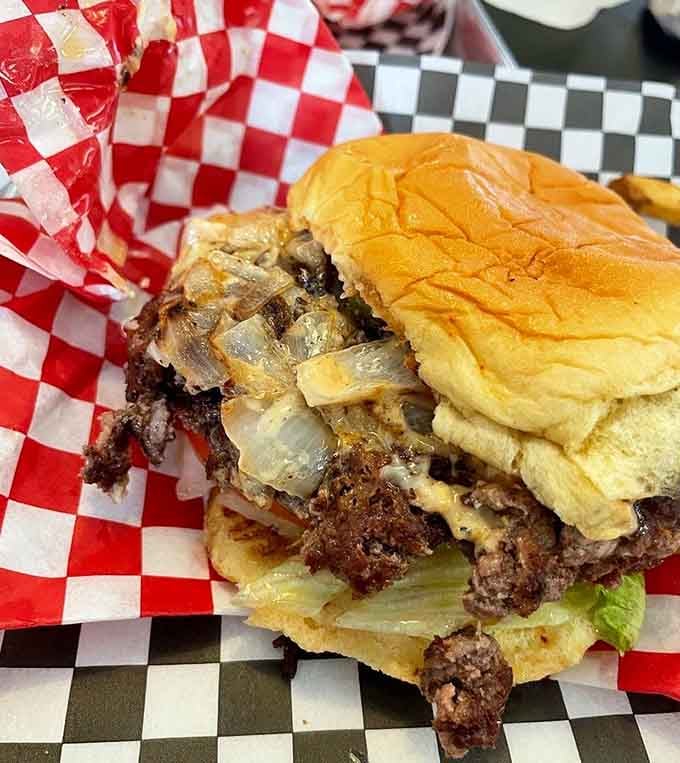 Two patties, melted cheese, and grilled onions stacked so perfectly it deserves its own architectural award ceremony.