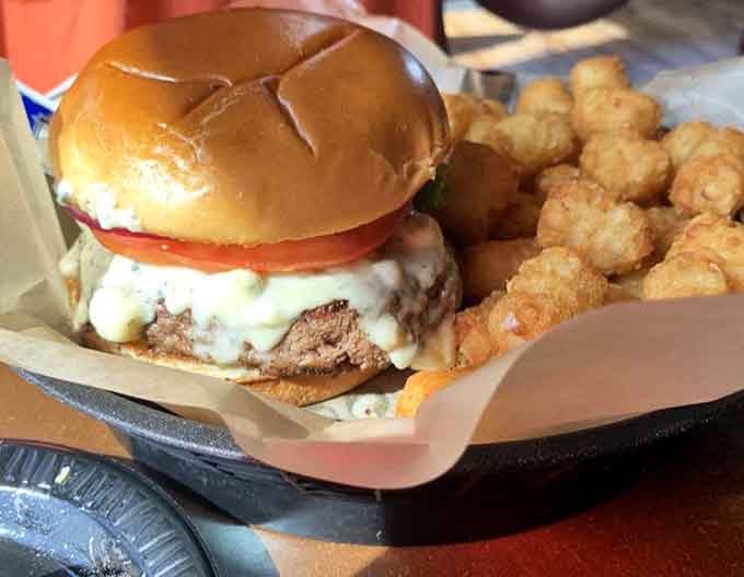 Behold: a burger so perfectly constructed it could teach engineering classes, accompanied by its golden, crispy sidekicks.