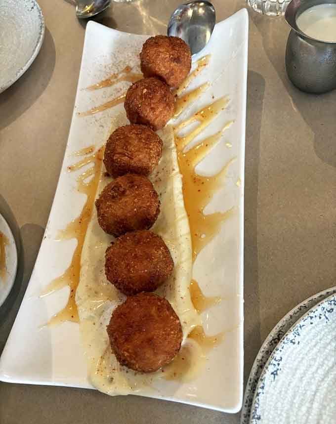 Golden croquetas lined up like edible soldiers, ready to wage delicious war on your hunger.