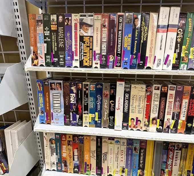 VHS tapes lined up like soldiers from a bygone era, ready to remind you when rewinding was actually a thing.