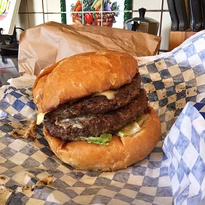 Two thick patties stacked high with melted cheese oozing down like a golden waterfall of happiness.