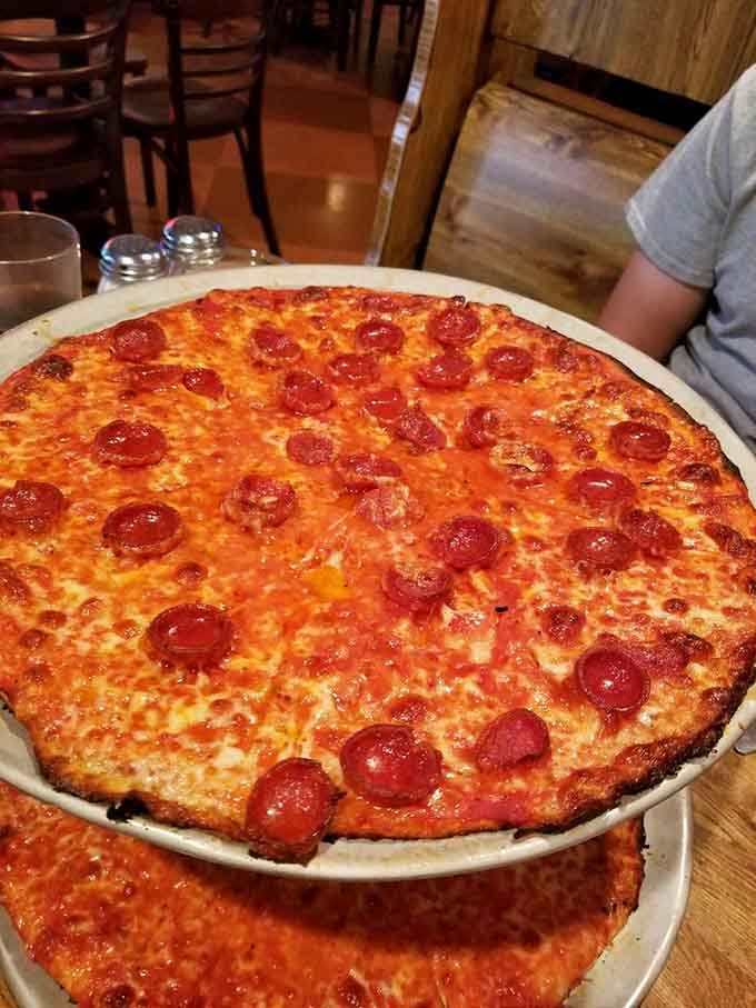 Pepperoni circles arranged like edible polka dots on a canvas of melted cheese and perfectly charred crust dreams.