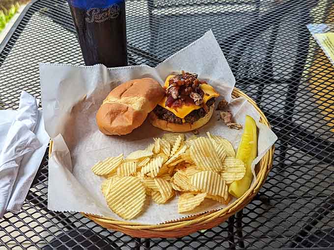 The burger arrives with chips and enough toppings to require architectural engineering, proving more is definitely more here.