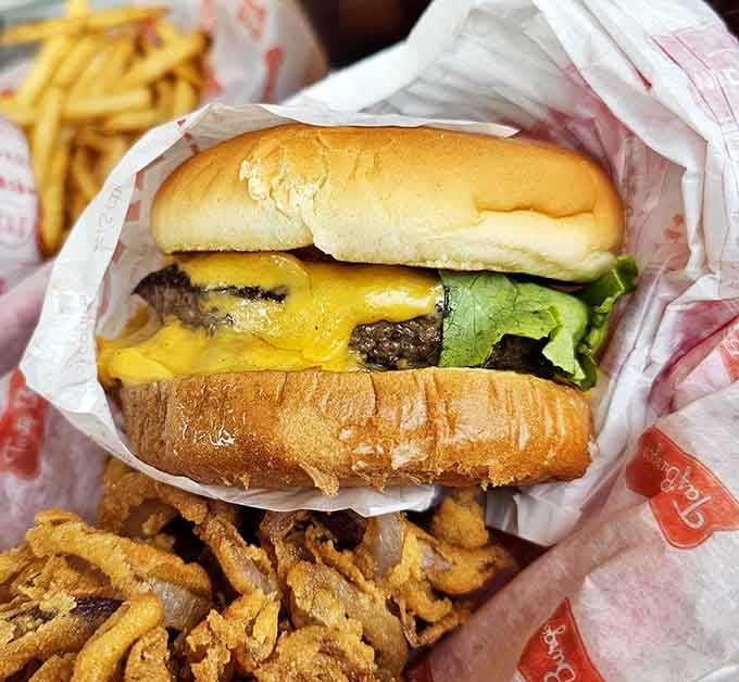 Golden cheese cascading over a perfectly cooked patty like a delicious avalanche you actually want to be caught in.