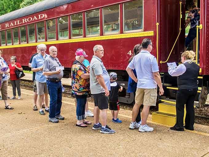 Fellow travelers gather trackside, united by anticipation and the timeless thrill of hearing "All aboard!" echo through pines.