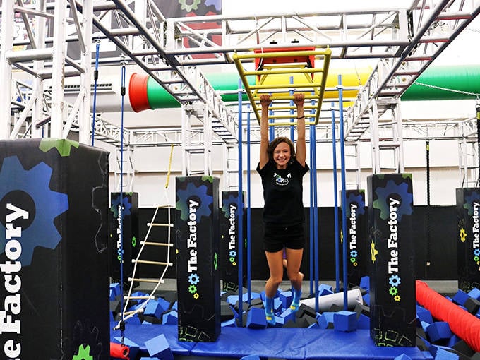 She's conquered the ninja course foam pit like a champion, grinning wider than a kid in a candy store.